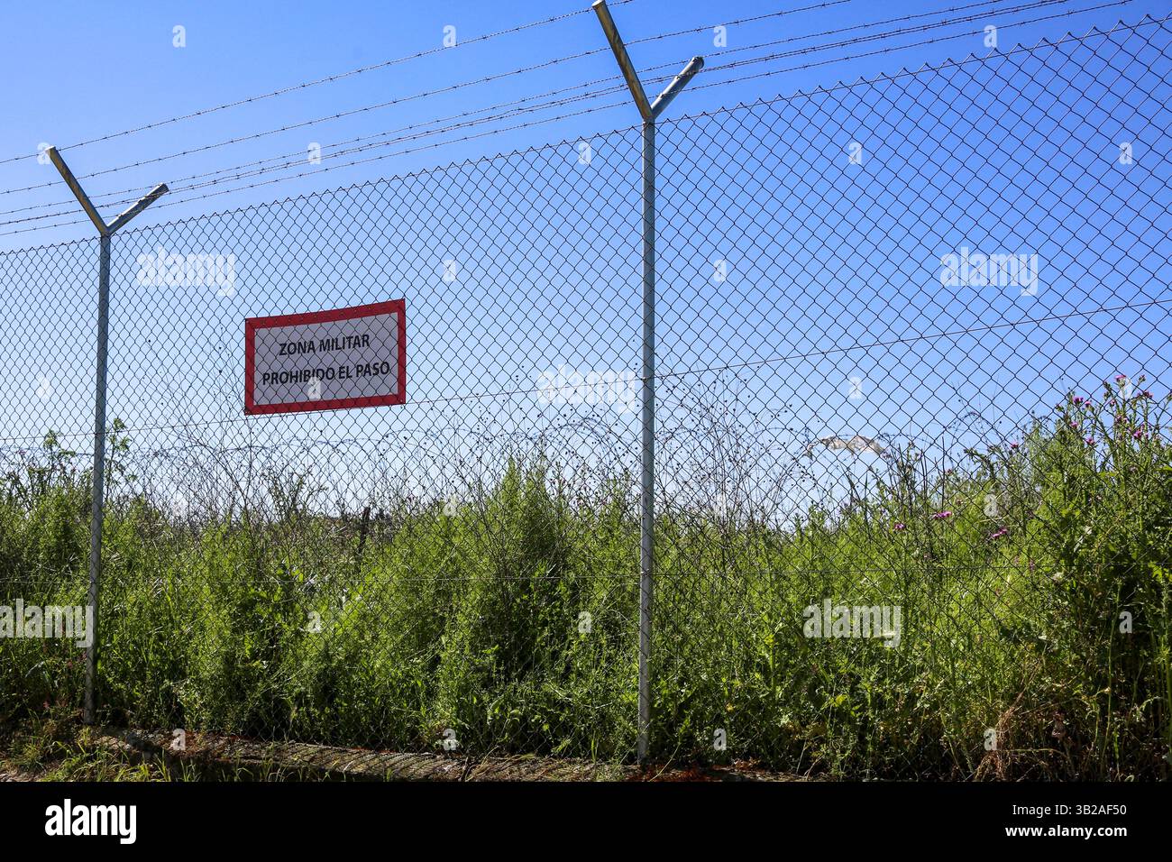 Translation: "Military zone, no entry." Barbed wire fence preventing ...