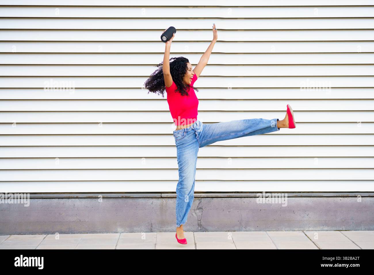 Dynamic and Joyful Dance Pose Captured Against a Striped Background for ...