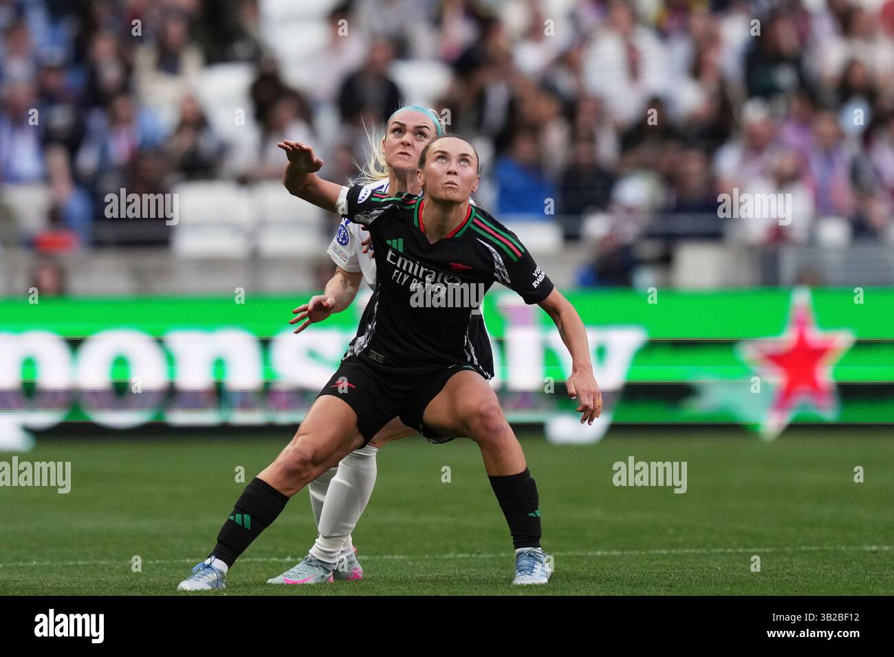 Arsenal's Caitlin Foord and Lyon's Ellie Carpenter, background, eye the ...