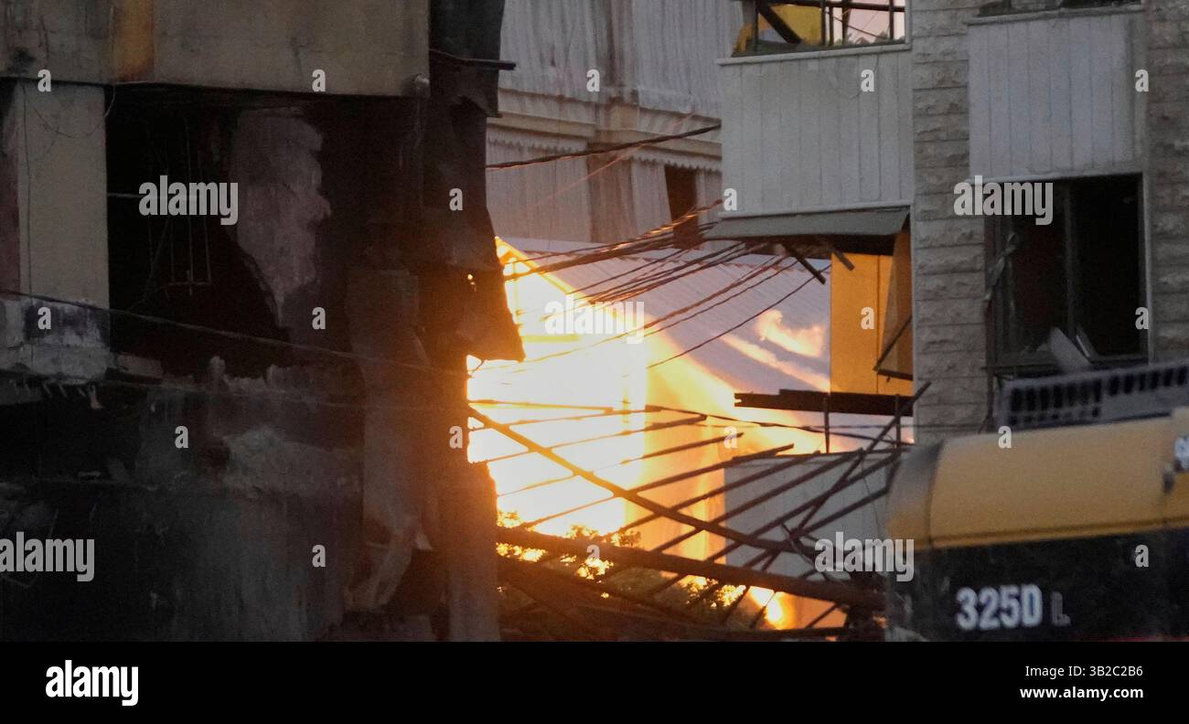 Flames burn between two buildings after an Israeli airstrike on Dahiyeh ...