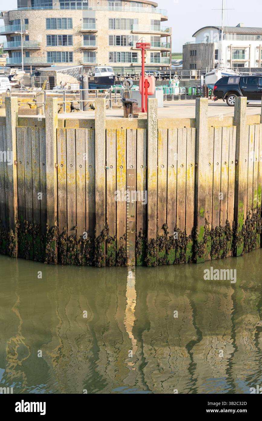 Wooden harbour wall incorporating a depth indicator at West Bay Dorset ...