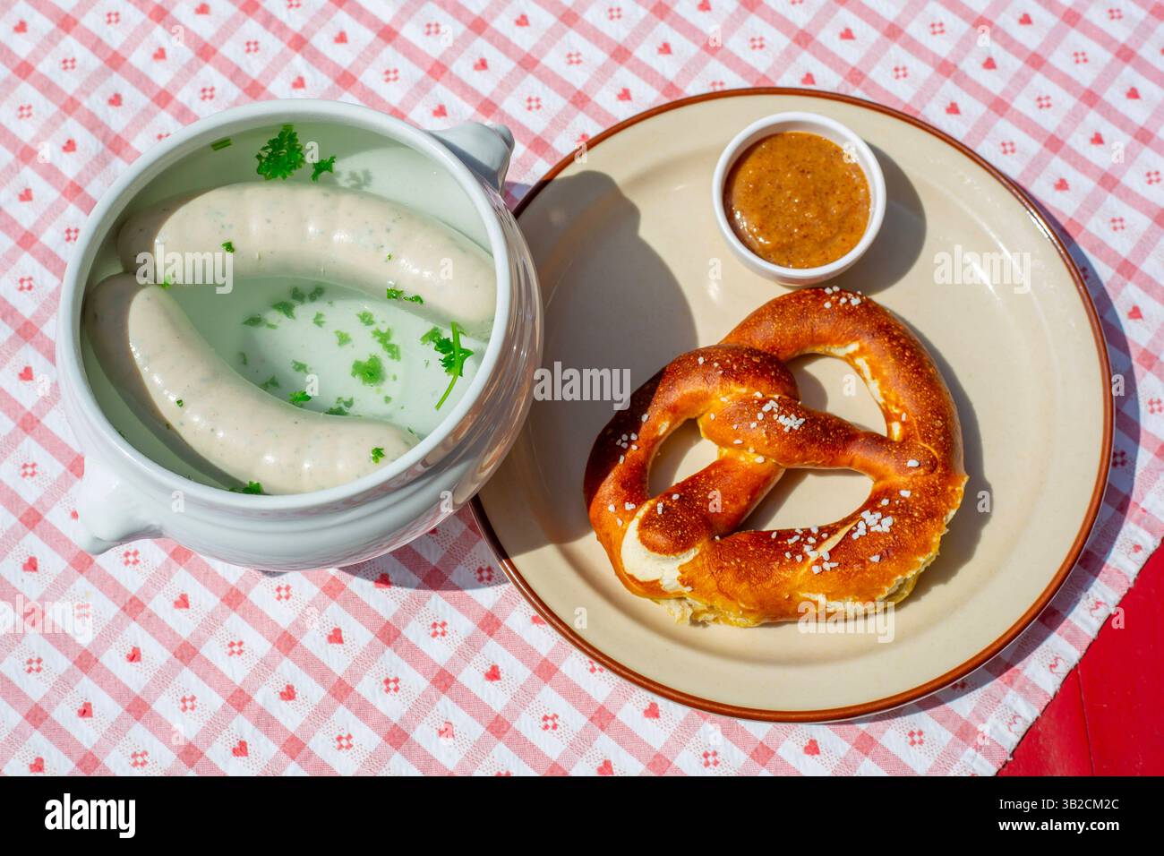 Weißwürste mit Brezel und Senf stehen auf einem Tisch in Bayern. Die ...
