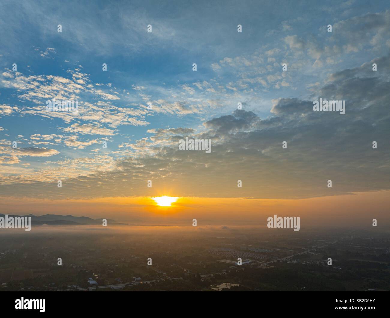 A breathtaking sunrise illuminates a small village nestled among lush ...