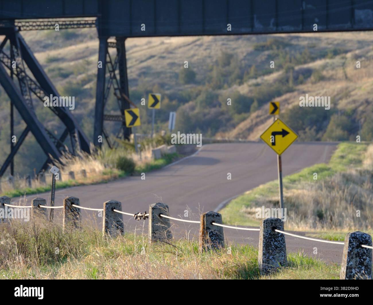 Curved Road Beneath Railway Bridge - A quiet rural road winds under a ...