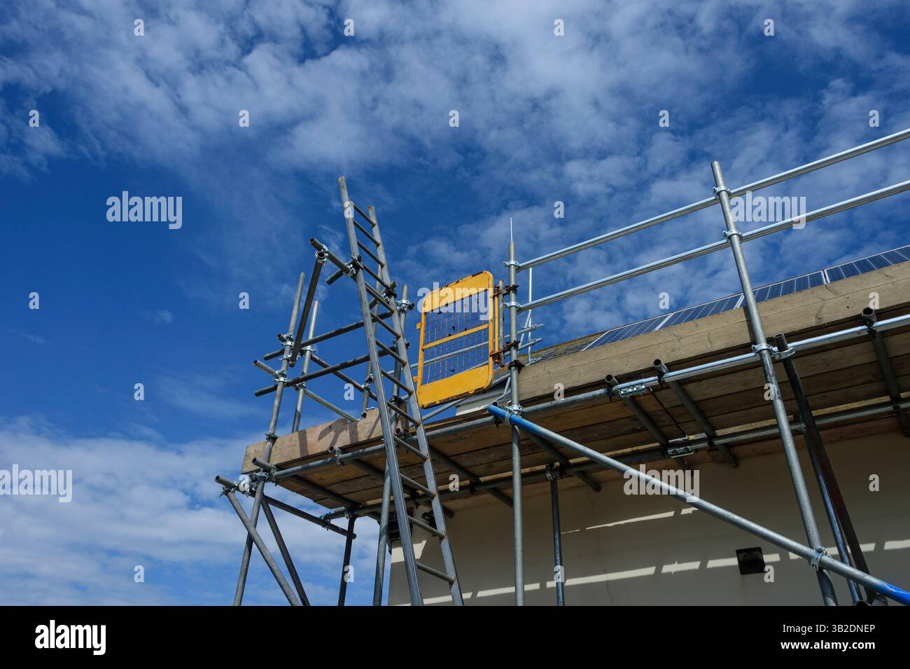 scaffolding on the side of a building with blue sky Stock Photo - Alamy