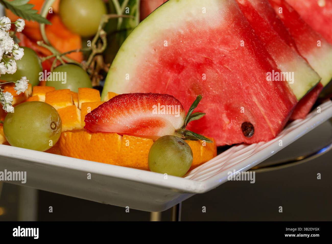 Colorful cut fruit platter on buffet table at outdoor birthday party ...