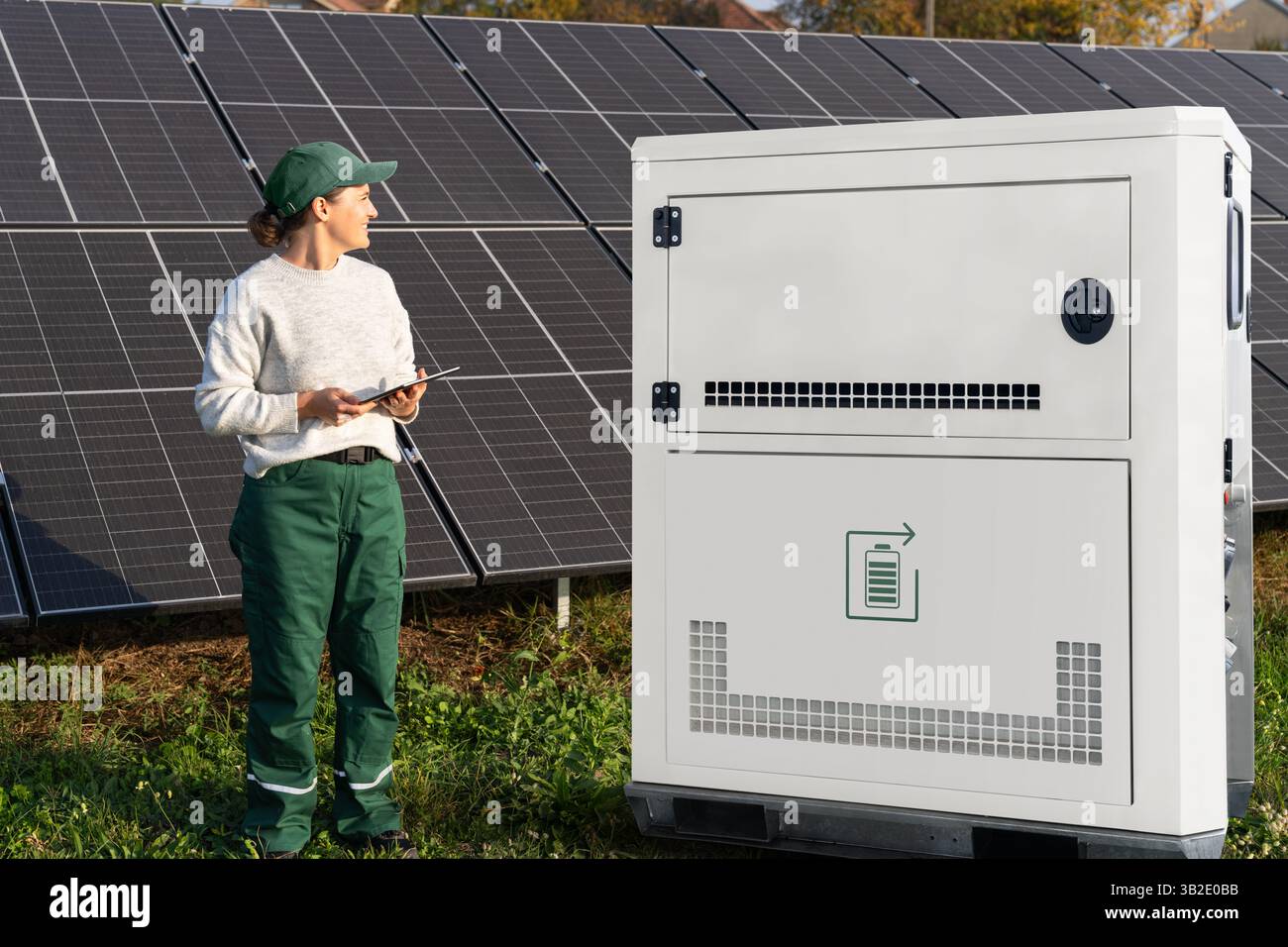 Farmer with digital tablet next to solar panels and energy storage ...