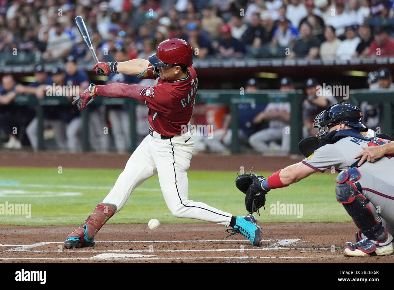 Arizona Diamondbacks' Corbin Carroll, left, fouls off a pitch as Atlanta Braves catcher Sean ...