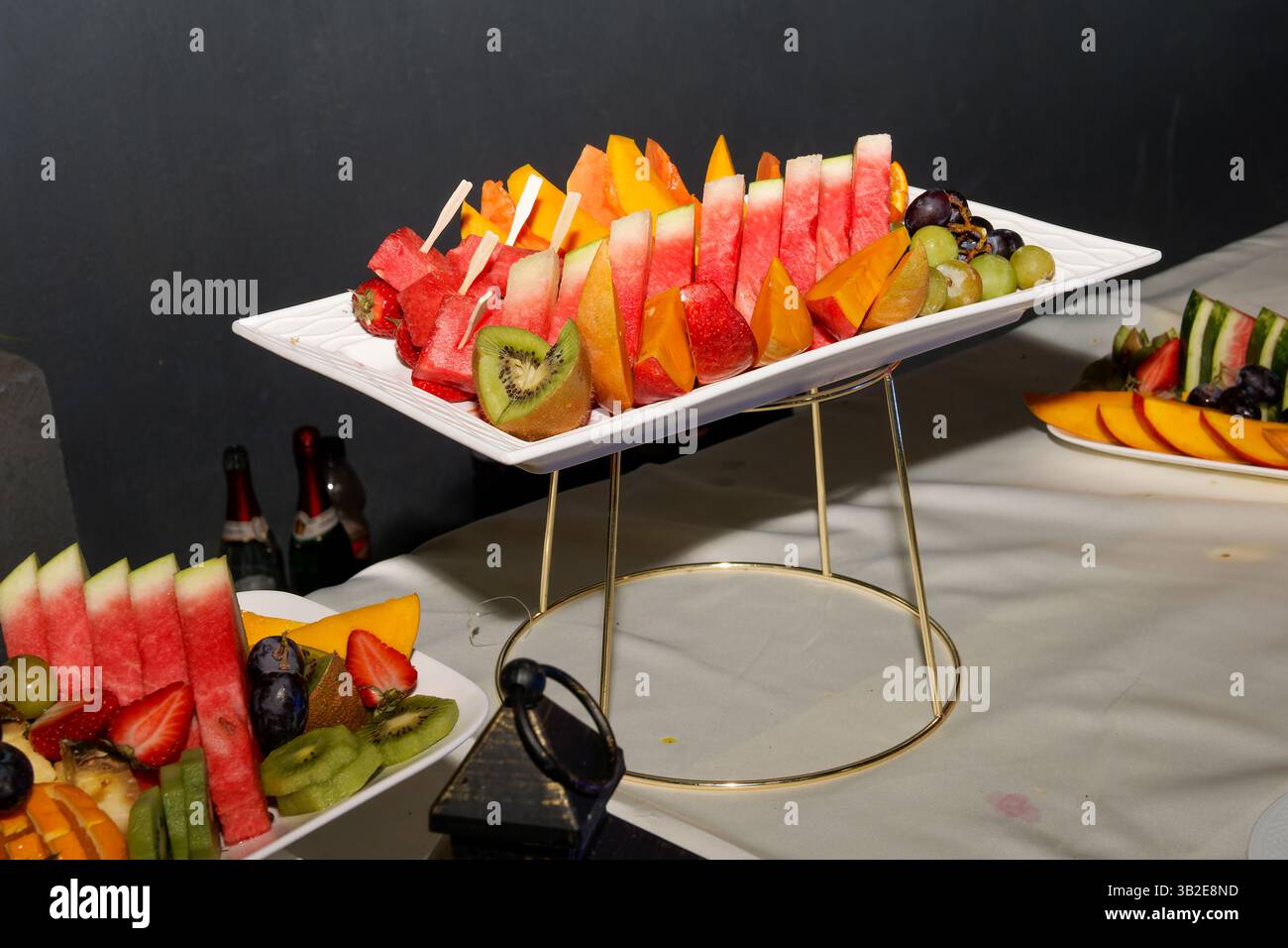 Colorful cut fruit platter on buffet table at outdoor birthday party ...