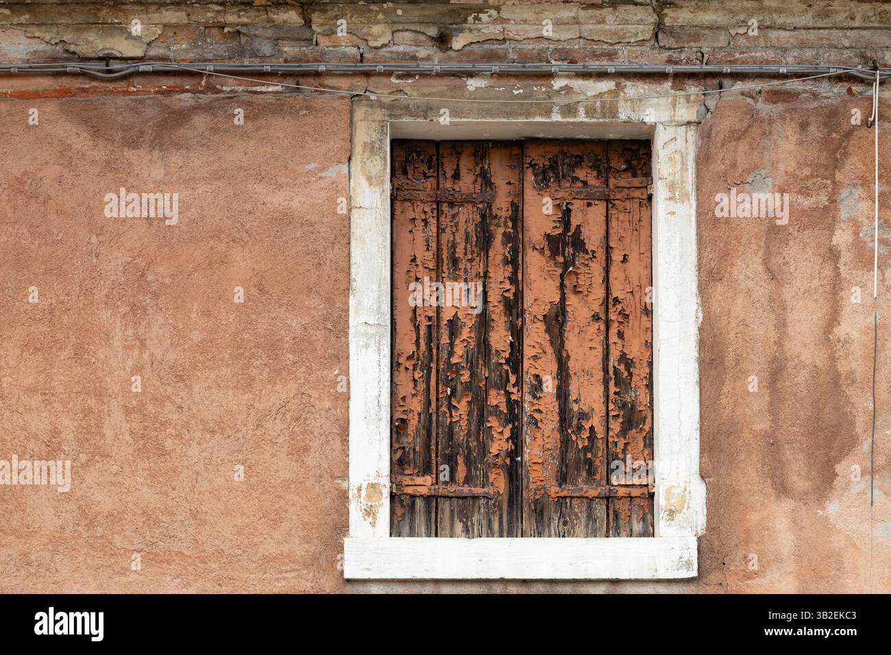 Old window with heavily weathered wooden shutters and rustic wall ...