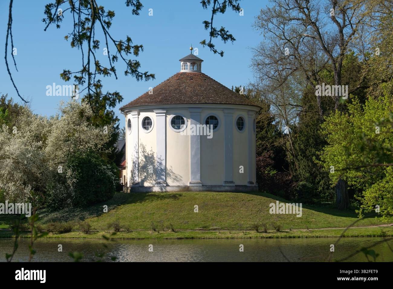 White rotunda on a hill in Verlitsky Park, spring landscape, reflection ...