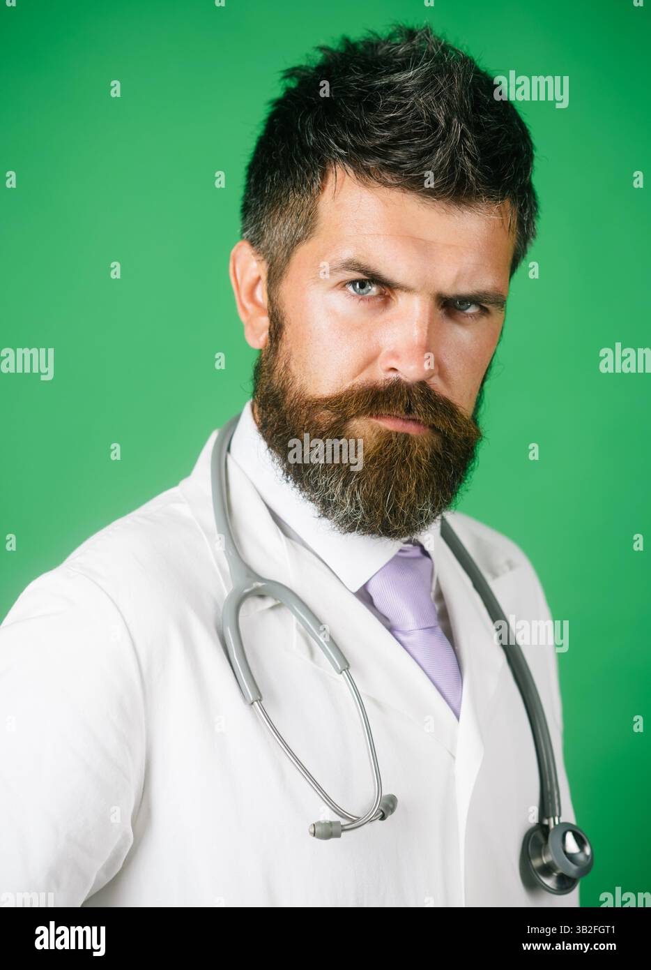 Portrait of serious doctor with beard and mustache in medical gown with ...
