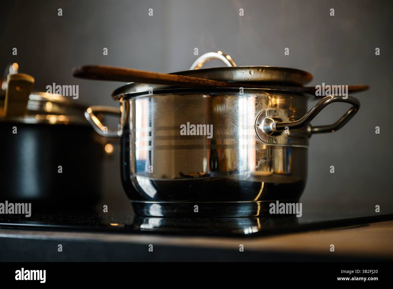 Cooking pots on induction cooktop in the kitchen, food preparation ...
