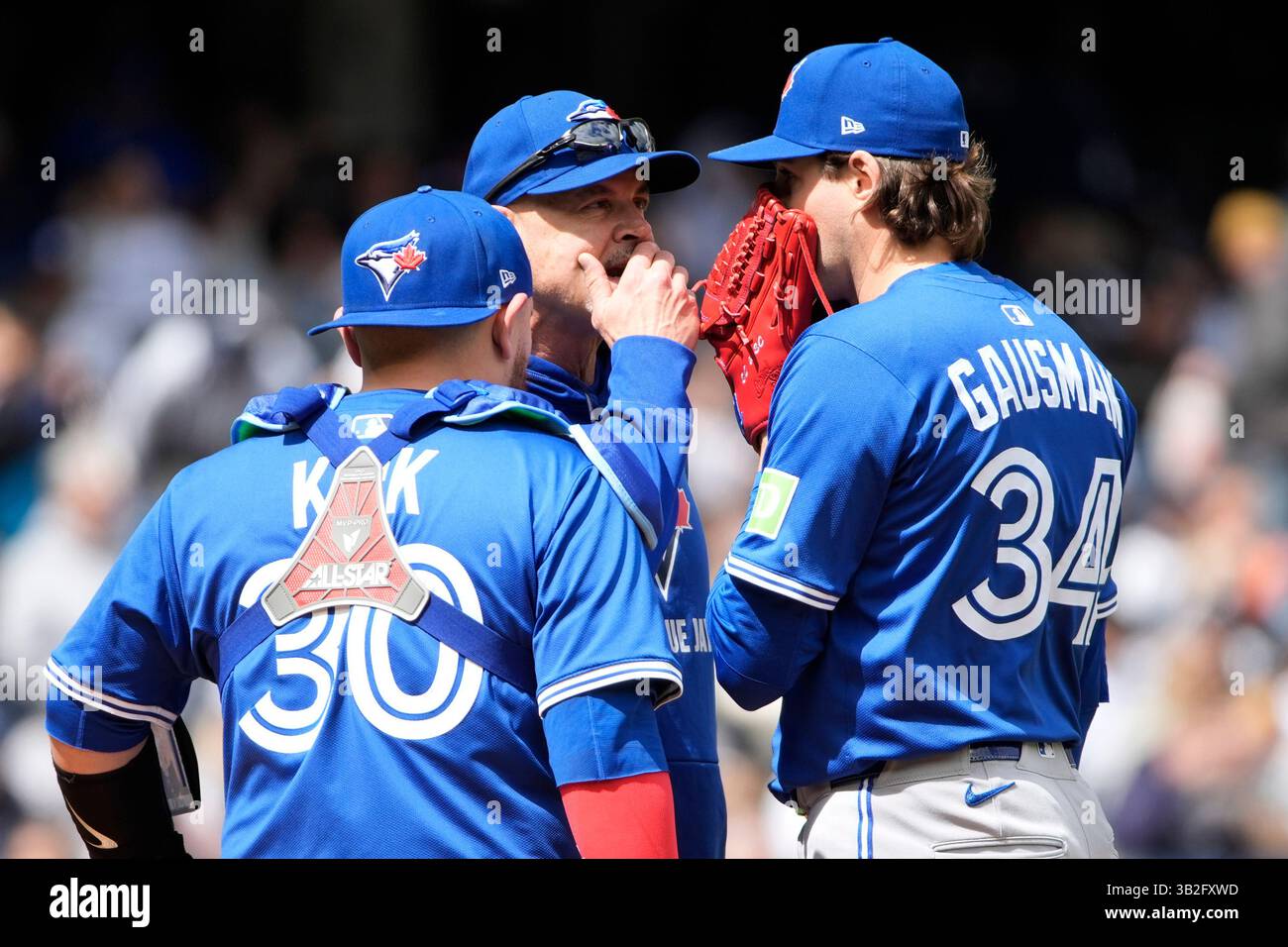 Toronto Blue Jays catcher Alejandro Kirk, left, and pitcher Kevin Gausman, right, talk to ...