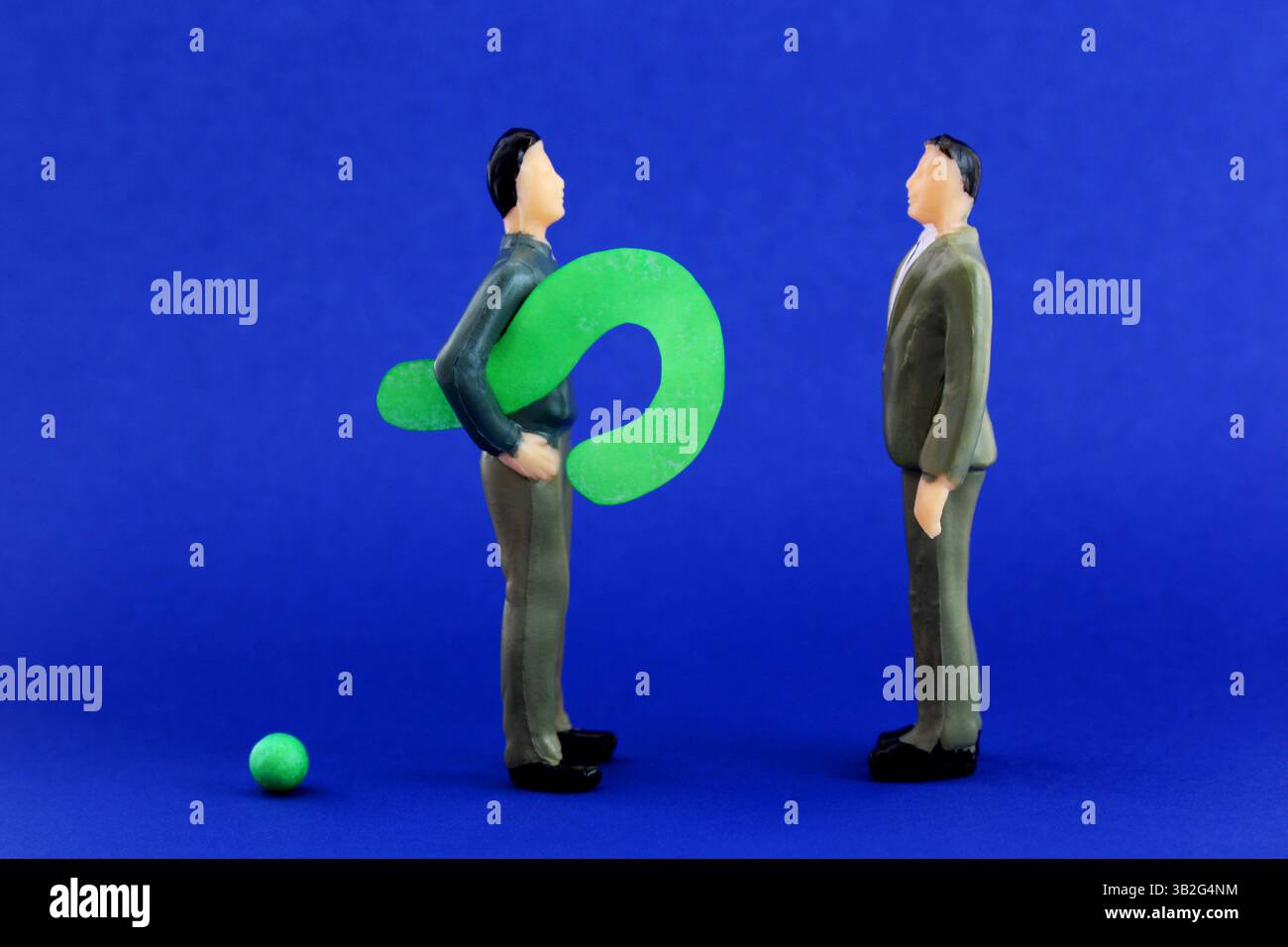 Business executive holding a question mark in front of coworker Stock ...