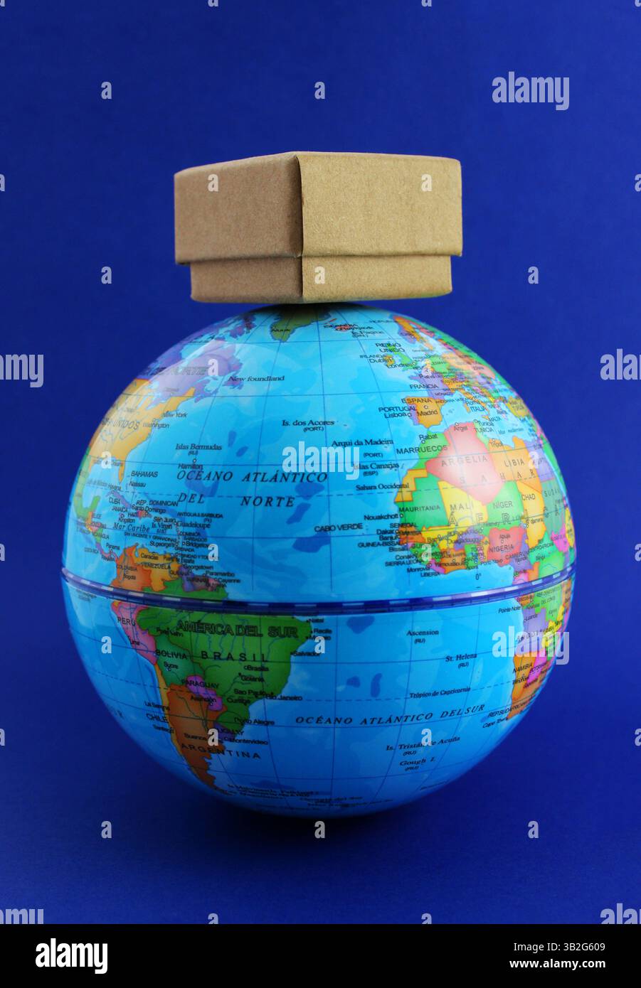 Cardboard box on planet Earth, package shipping Stock Photo - Alamy