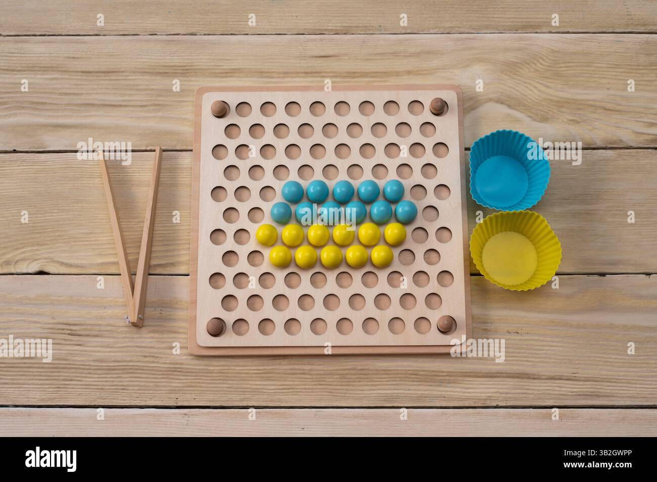 Montessori game with yellow and blue balls. Develops fine motor skills ...