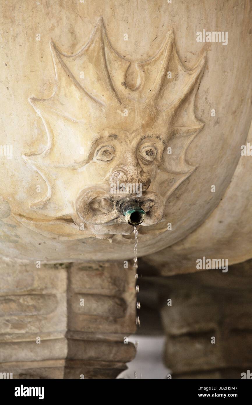 A dragon head fountain features intricate carvings, set in the historic ...