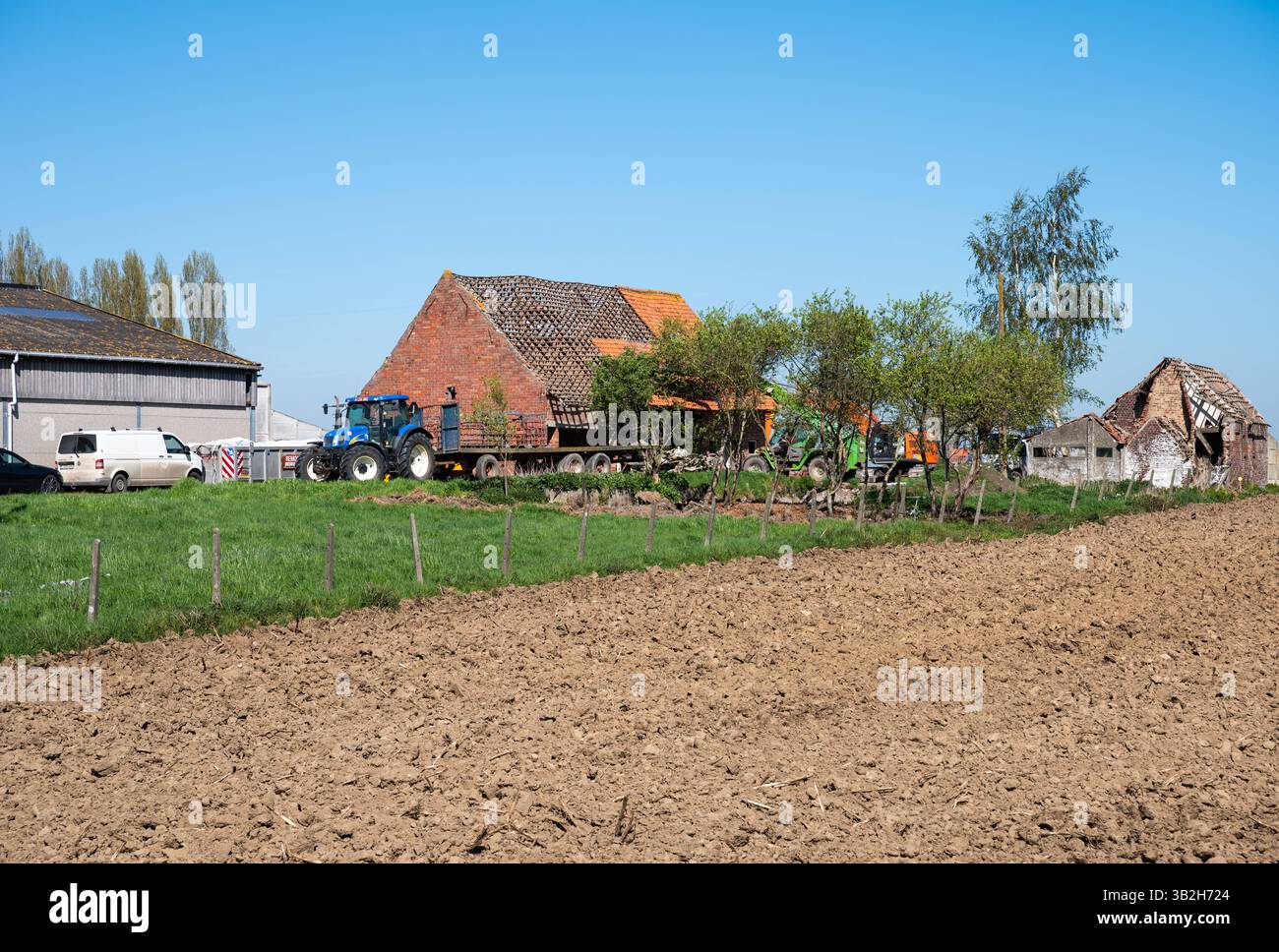 Farm house with staple and tractor combines at the Flemish countryside ...