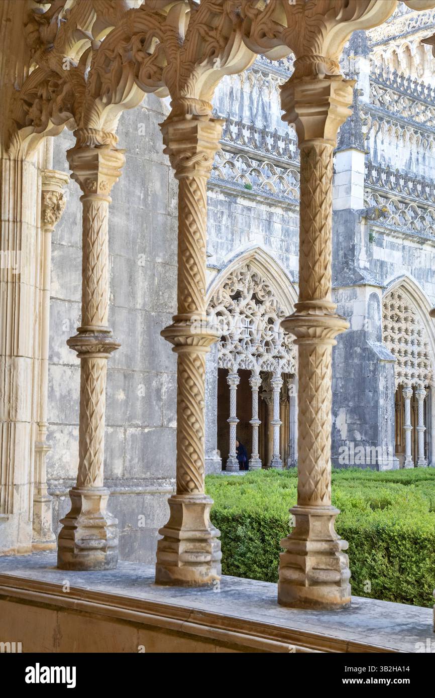 Detailed columns and lush greenery of Batalha Monastery's cloister ...