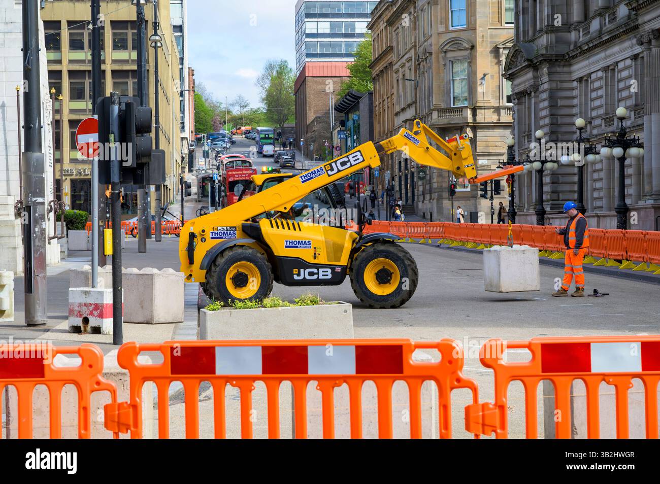A JCB Telehandler being used to move concrete barrier blocks into place ...