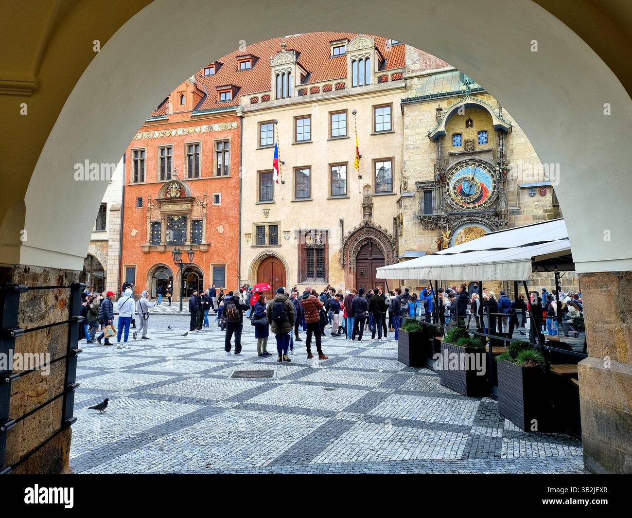 View through the arch of the building to the crowd of people waiting for a unique show with ...