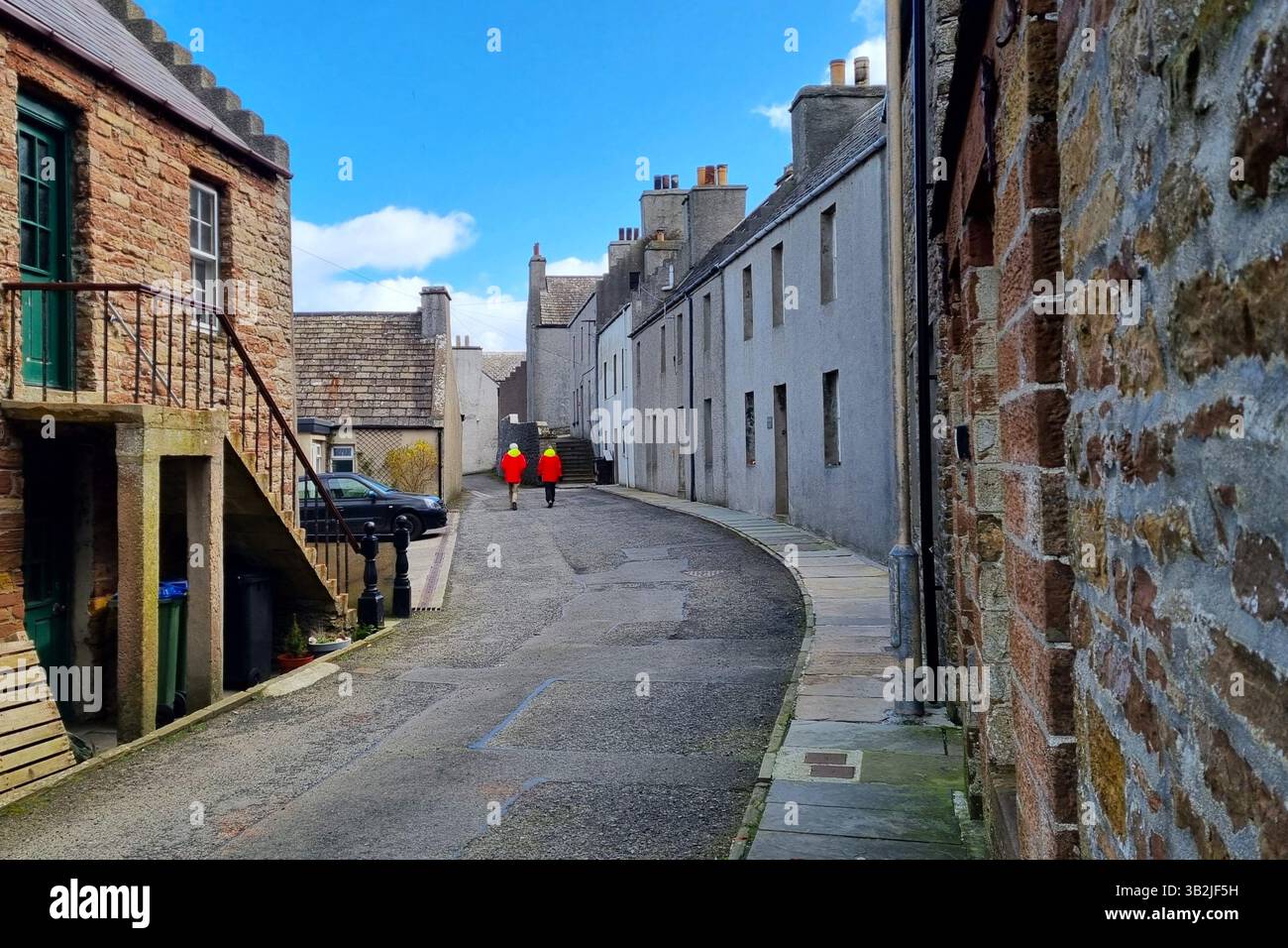 Cruise ship passengers stroll down a typical narrow street with old ...