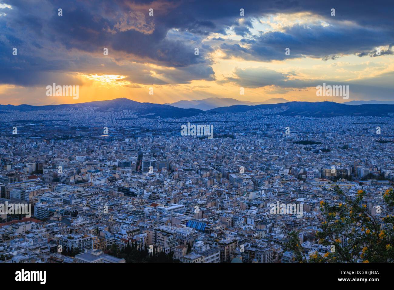 Sun sets over the Greek capital of Athens, with the city sprawling into ...