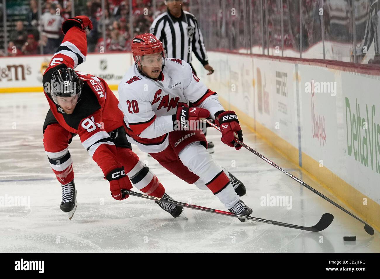 New Jersey Devils' Dawson Mercer, left, and Carolina Hurricanes ...