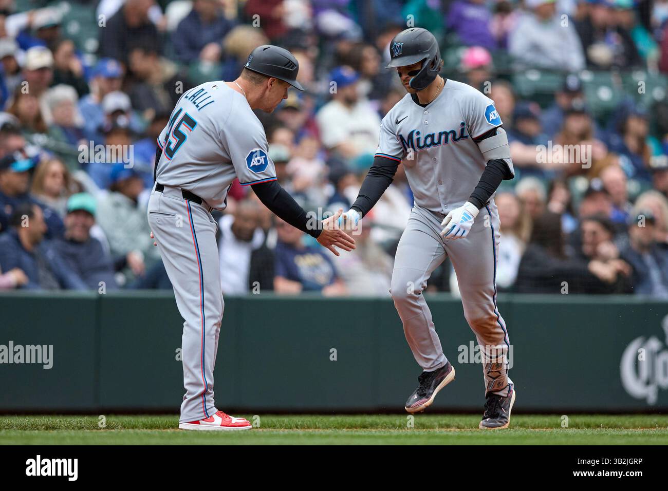 Miami Marlins' Connor Norby, right, celebrates with third base coach ...