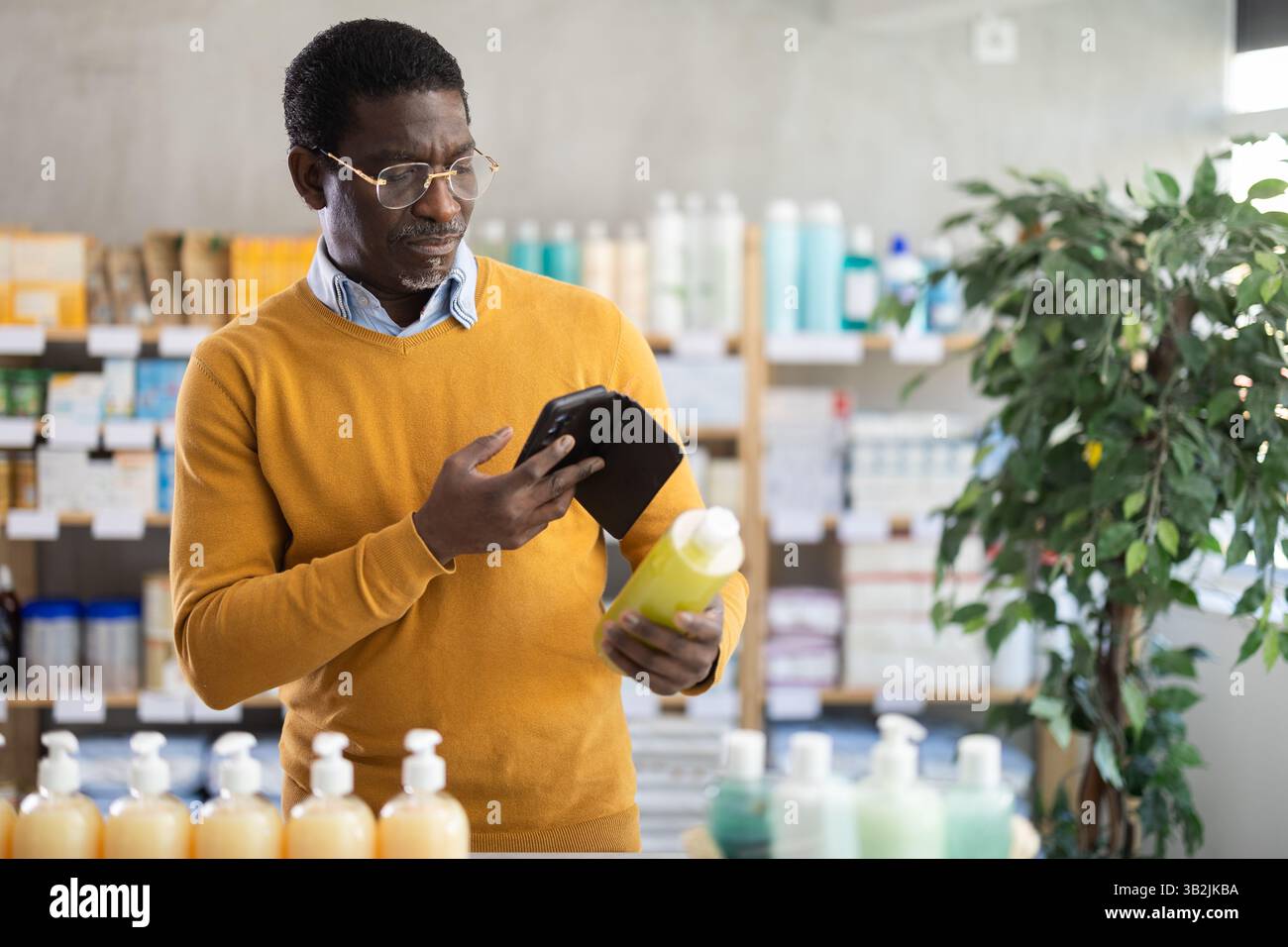Male customer scanning QR code on bottle on shampoo in store Stock ...