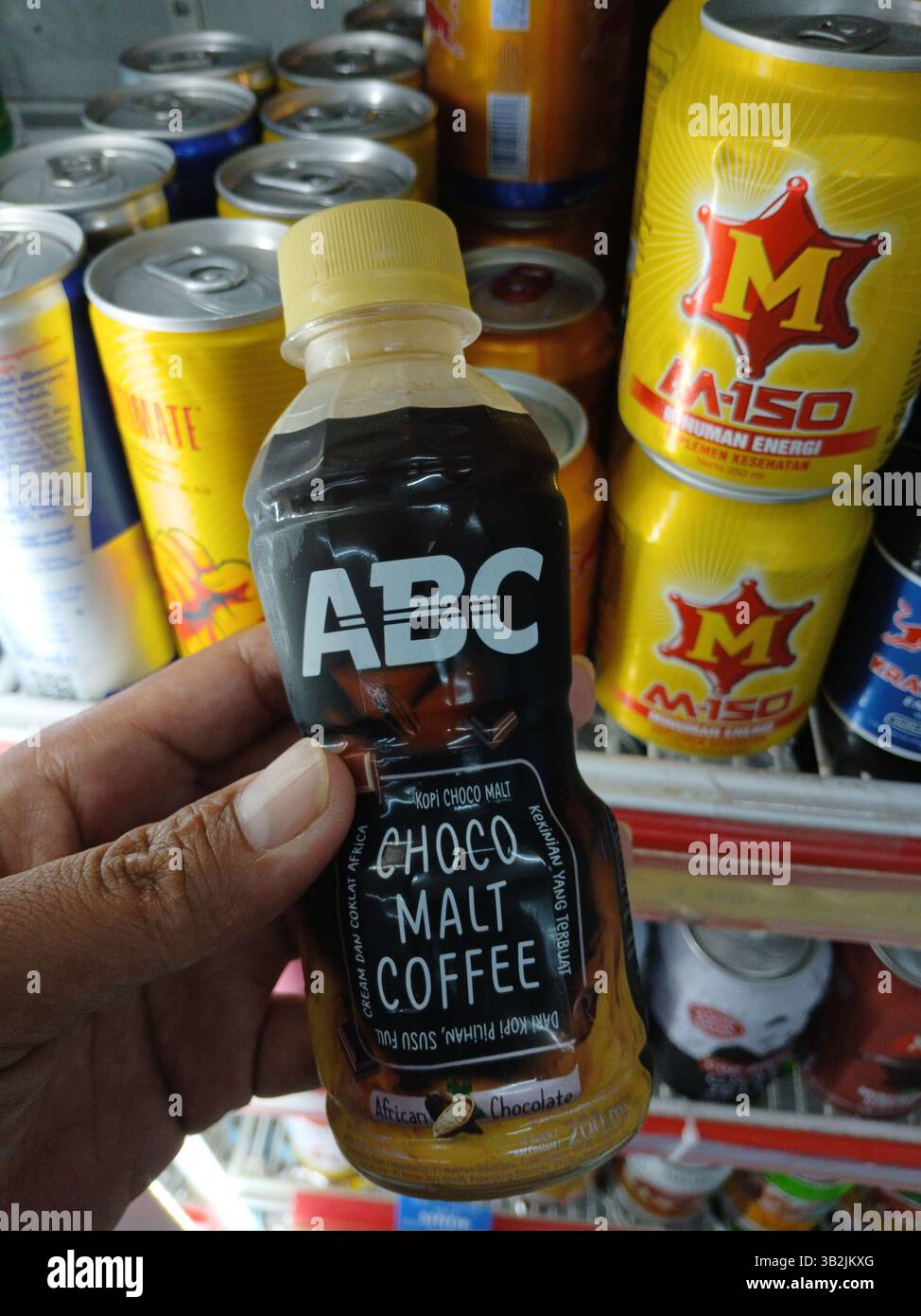 A Hand is holding and scanning a sweet bottled drink in the supermarket ...