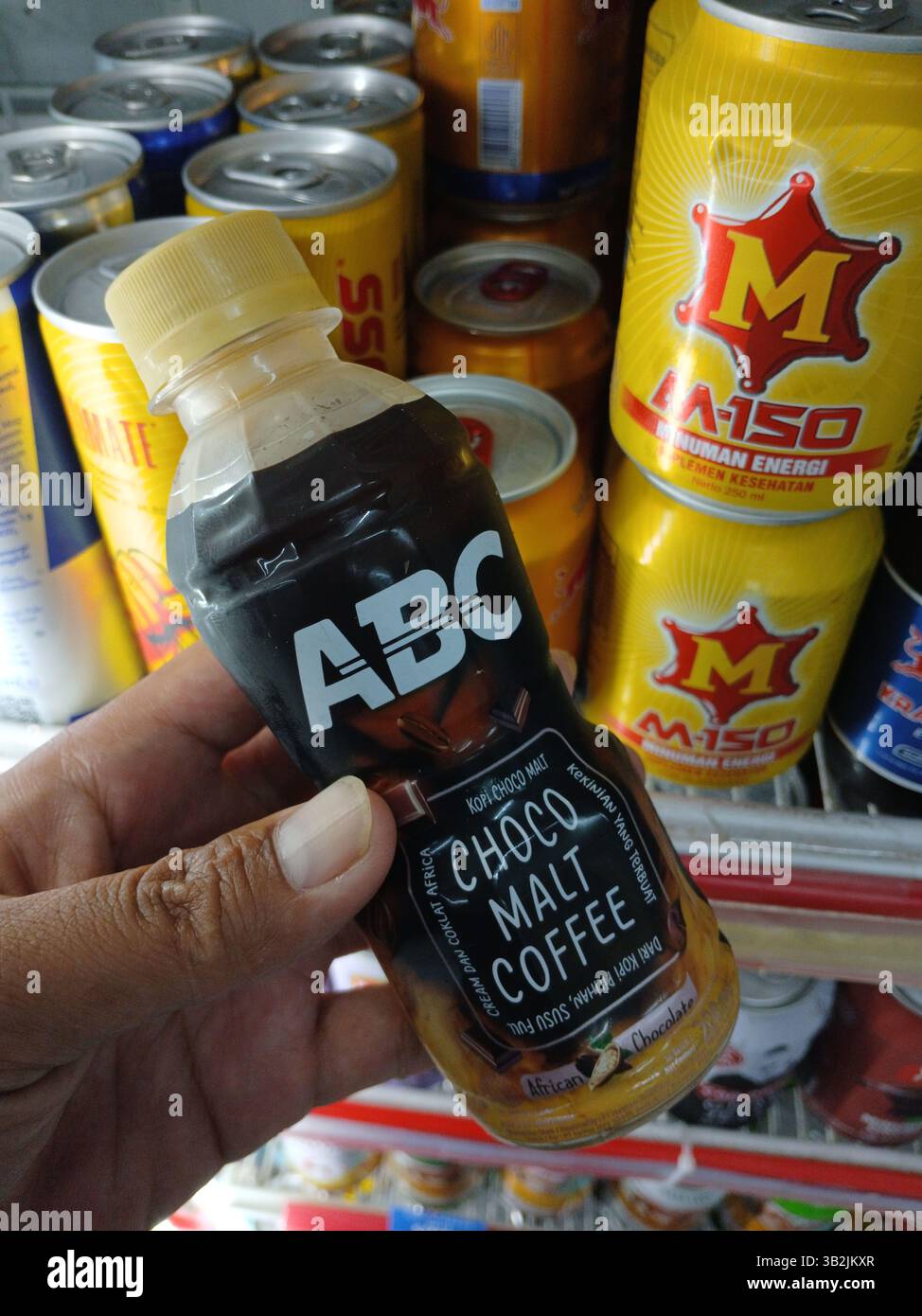 A Hand is holding and scanning a sweet bottled drink in the supermarket ...