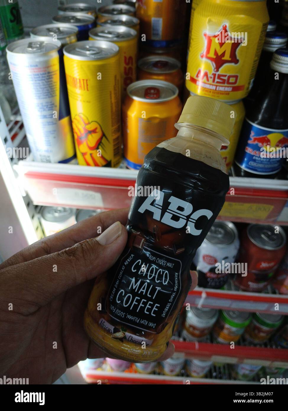 A Hand is holding and scanning a sweet bottled drink in the supermarket ...