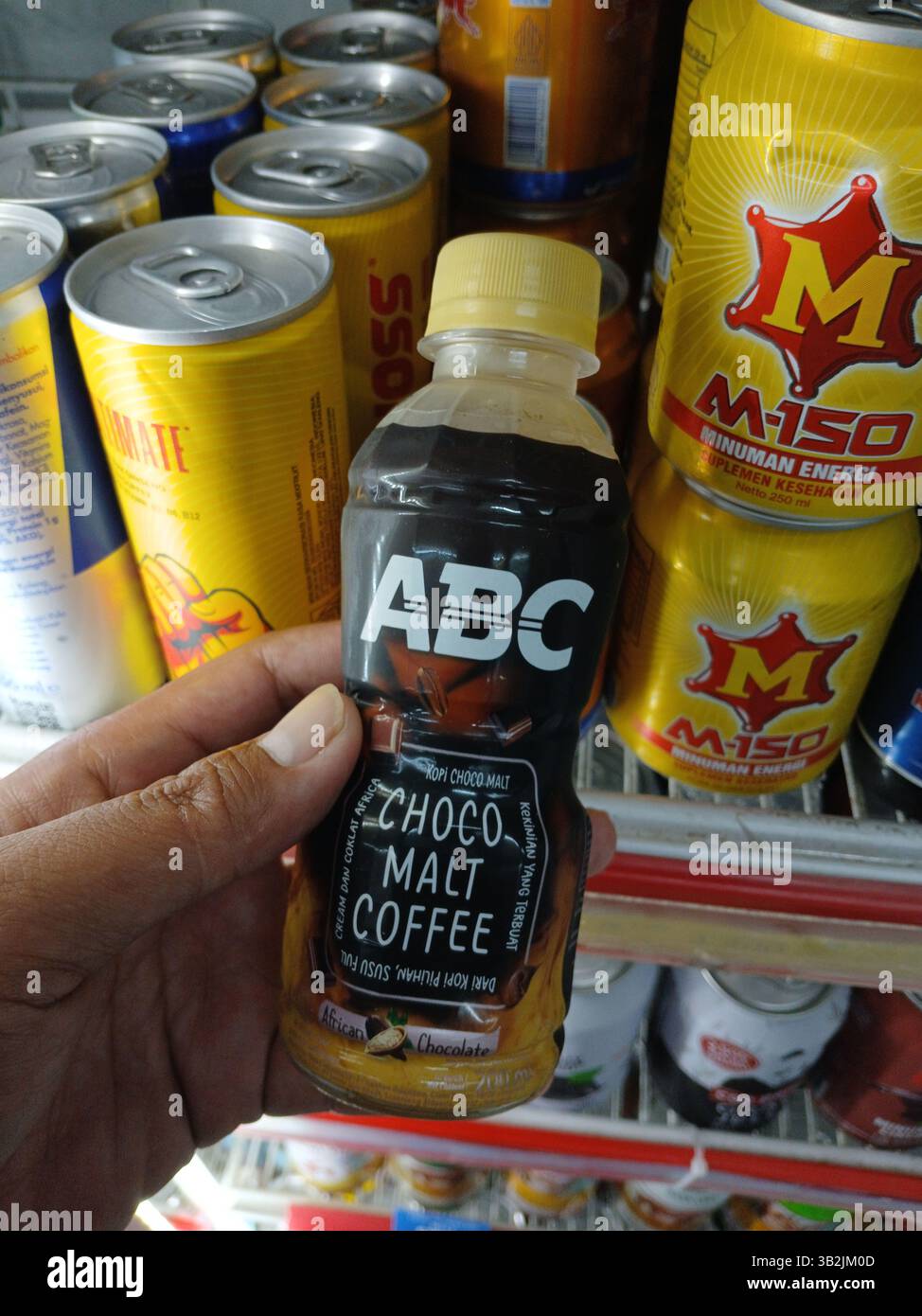 A Hand is holding and scanning a sweet bottled drink in the supermarket ...