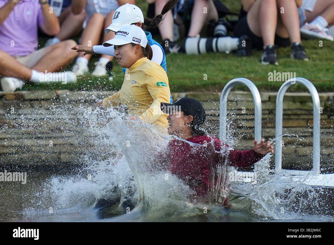 Mao Saigo, of Japan, in yellow, jumps into the water after winning the ...