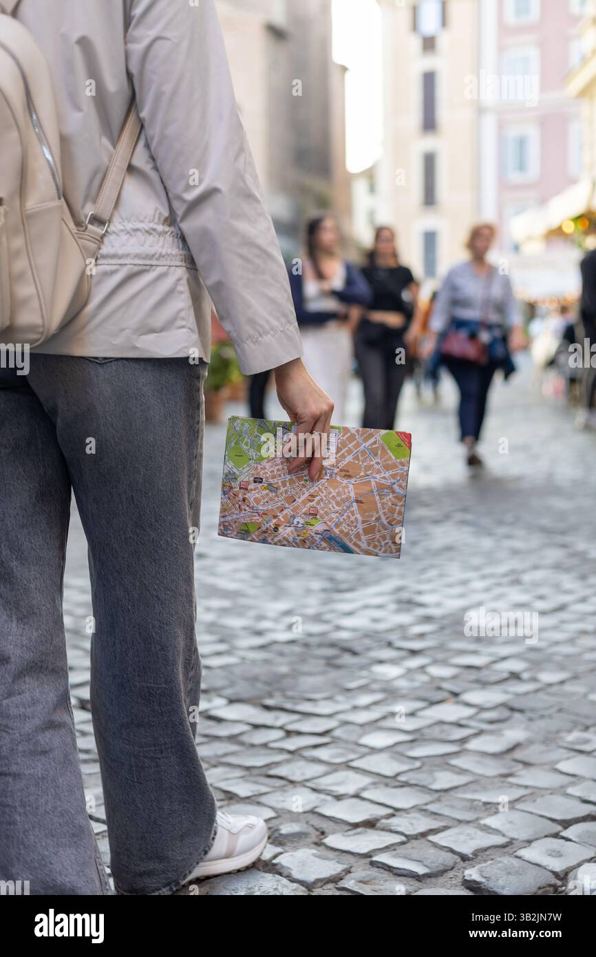 A wanderer stands on charming cobblestones, map in hand, gazing at the ...