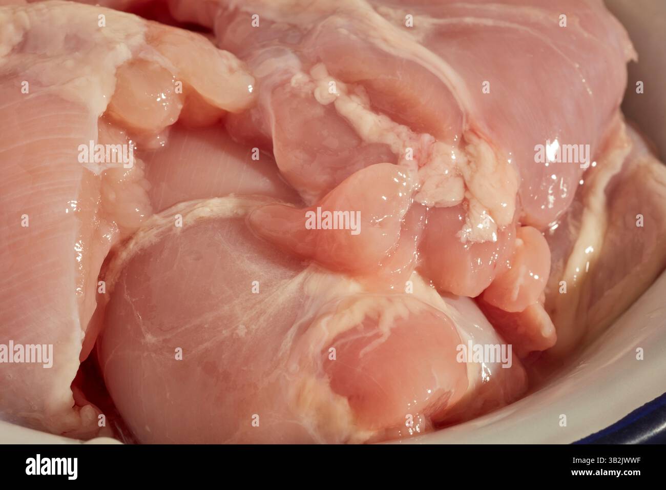 A bowl of raw, skinless, boneless chicken thigh meat Stock Photo - Alamy