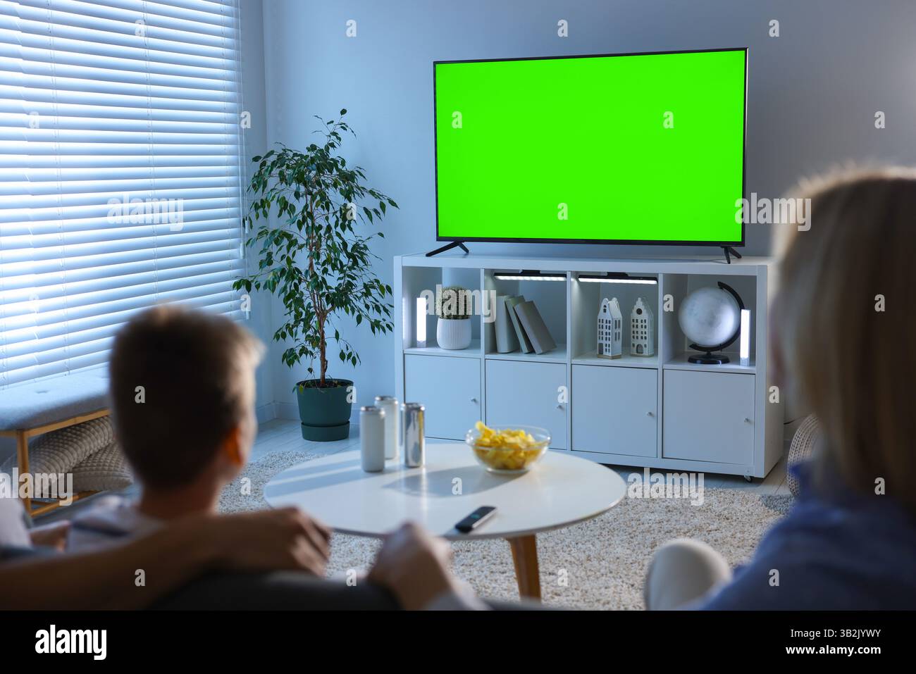 Family watching modern TV set with green screen at home. Chroma key ...