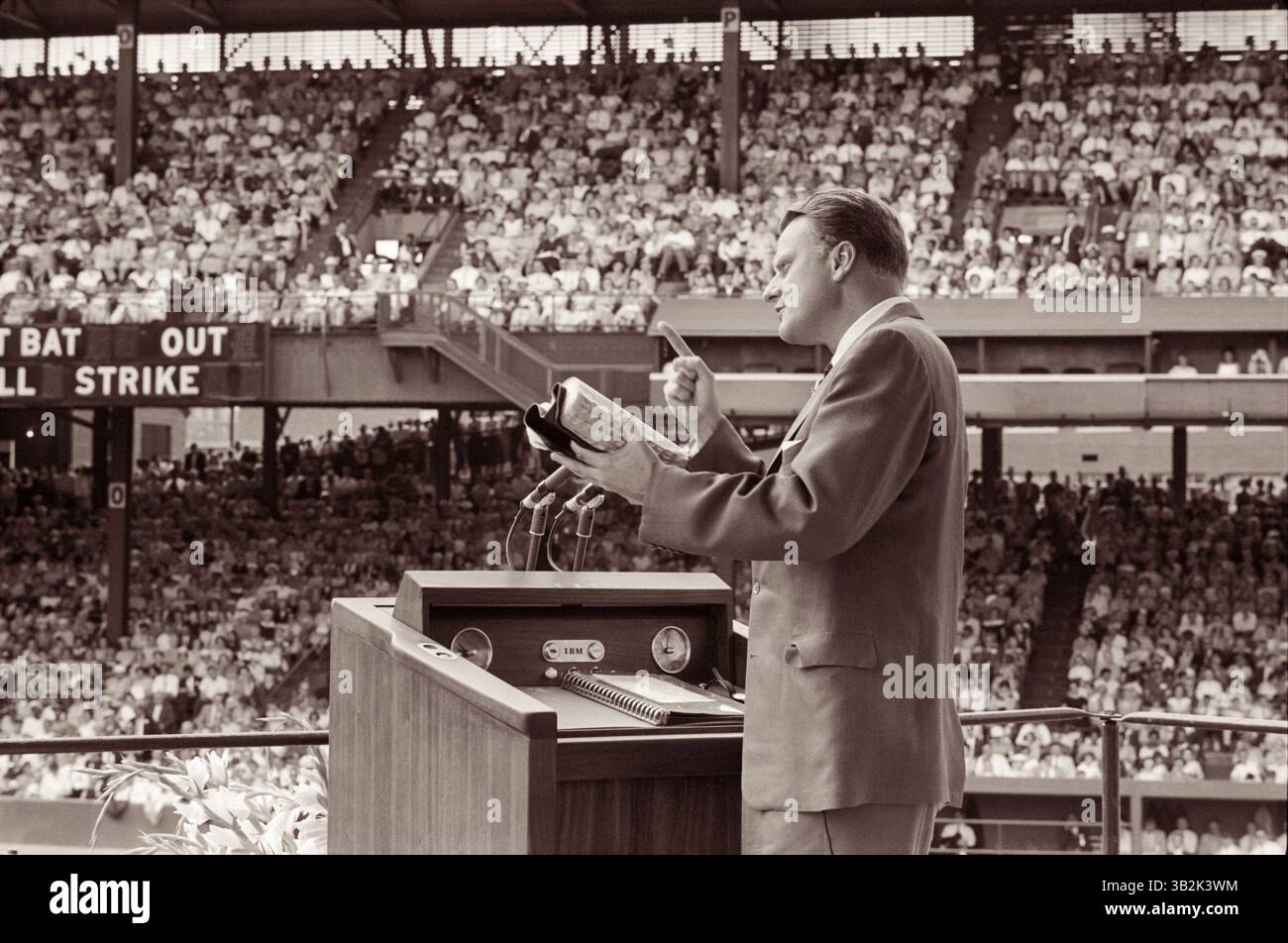 American evangelist Billy Graham preaching from the Bible at a ...