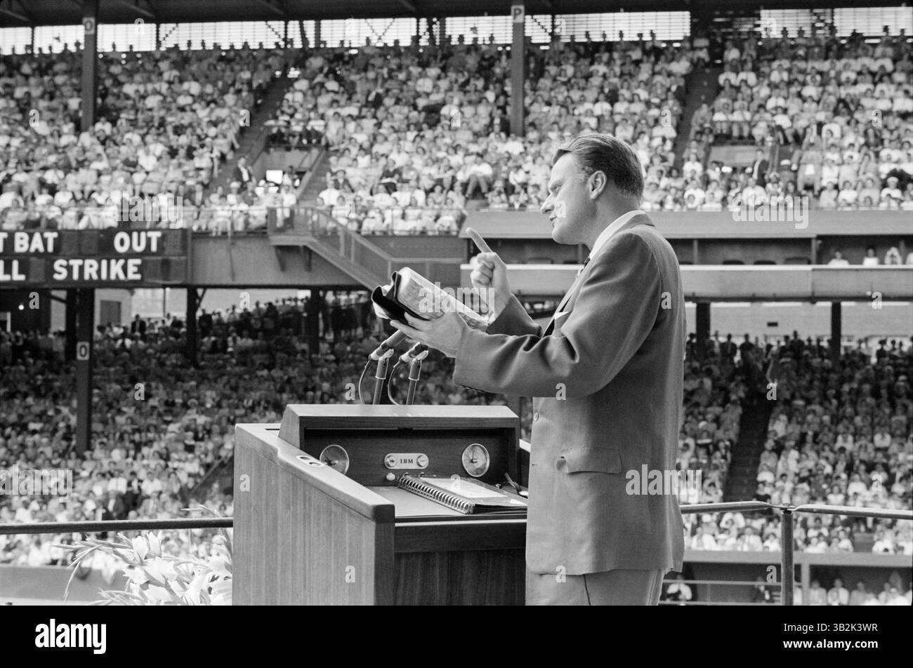 American evangelist Billy Graham preaching from the Bible at a ...