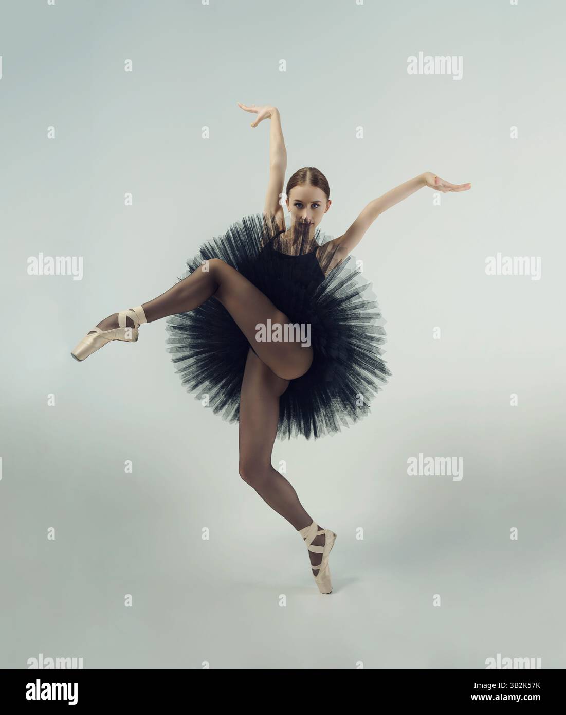 a ballerina in a black tutu shows elements of ballet dance in motion ...