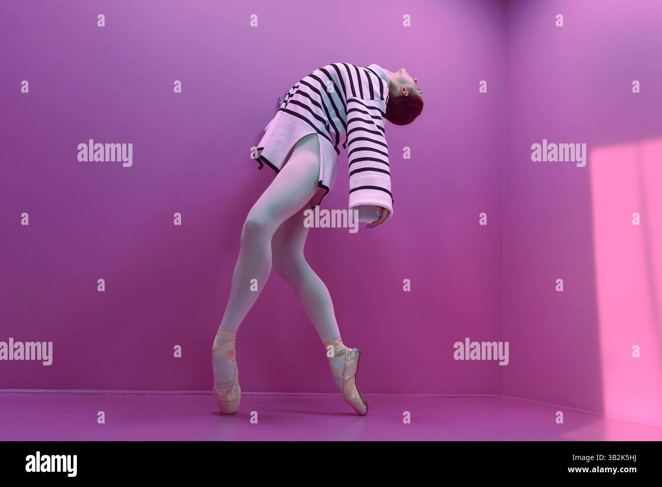 a young ballerina in white tights and a half-skirt poses ballet steps ...