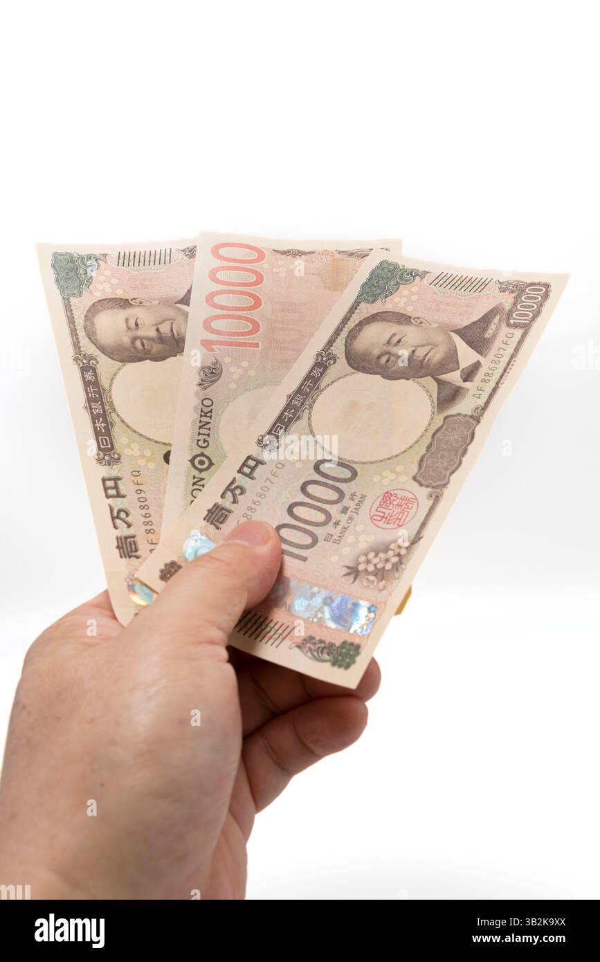 Hand holding new 10,000 yen banknote of Japan isolated on white ...
