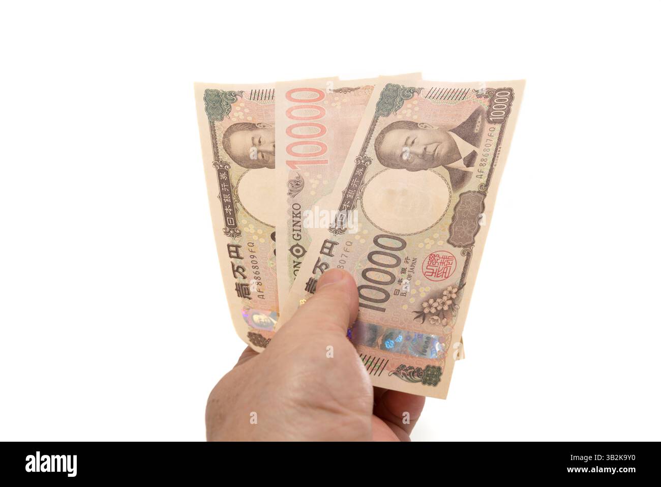Hand holding new 10,000 yen banknote of Japan isolated on white ...