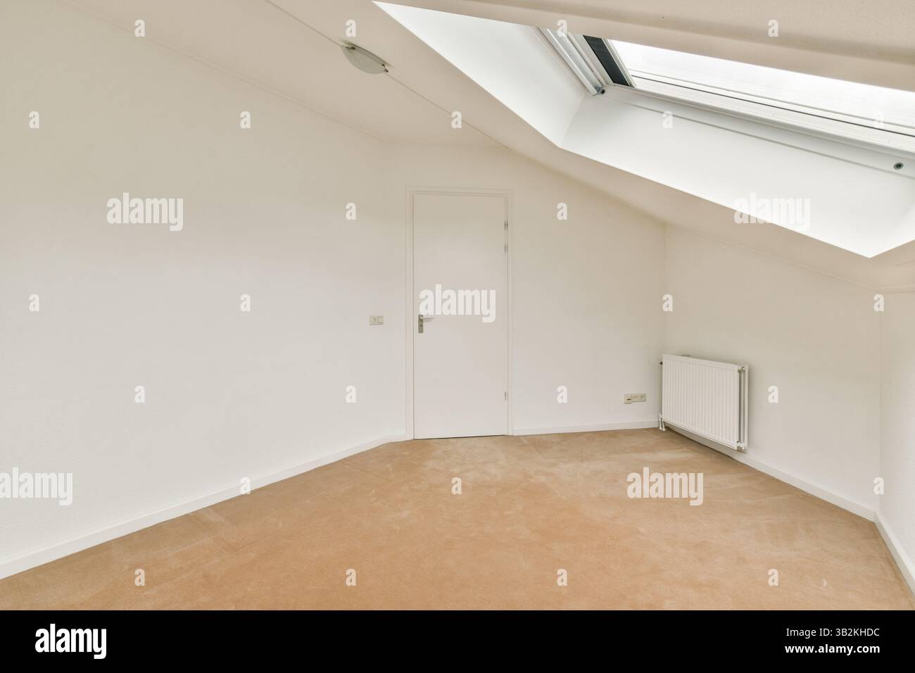 A spacious interior featuring soft light pouring through a skylight ...