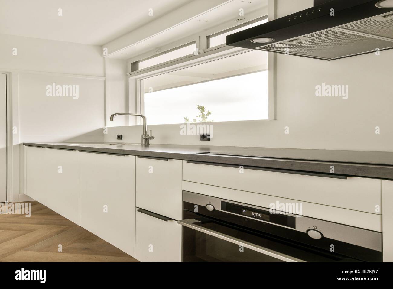 A sleek modern kitchen featuring minimalist cabinetry, a stylish sink ...