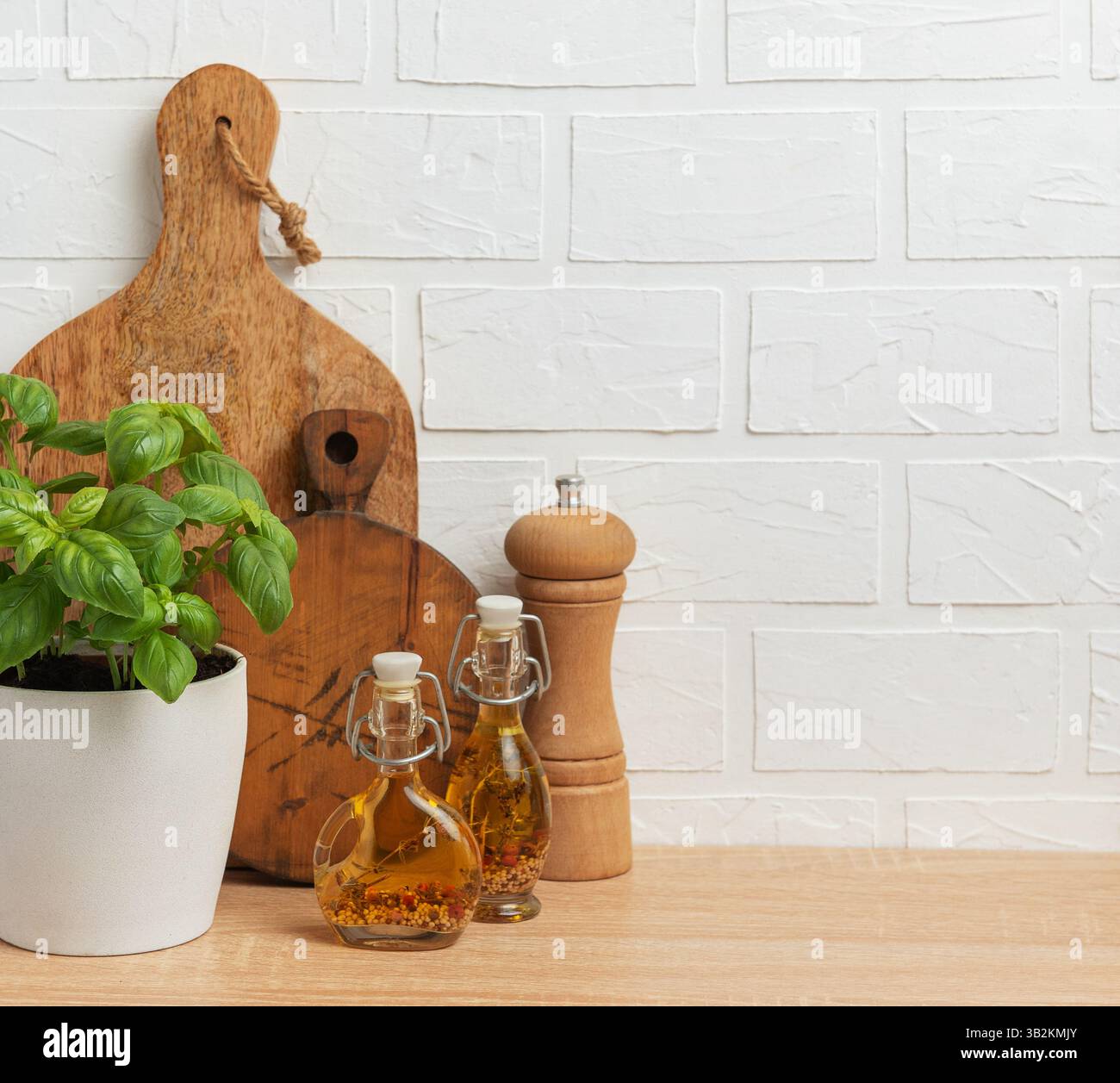 Kitchen counter with fresh basil plant, olive oil bottles, pepper mill ...