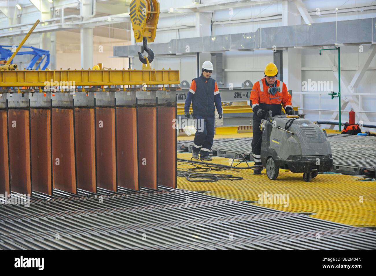 A worker washes plates with cathode copper at an industrial plant Stock ...