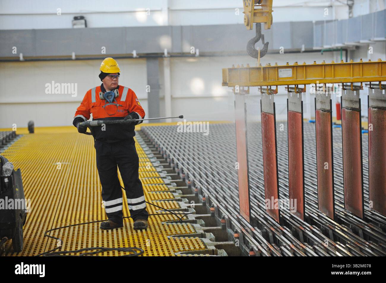 A worker washes plates with cathode copper at an industrial plant Stock ...